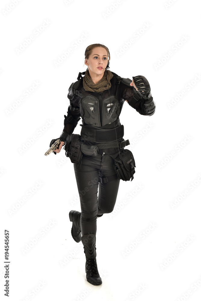 full length portrait of female soldier wearing black tactical armour ...