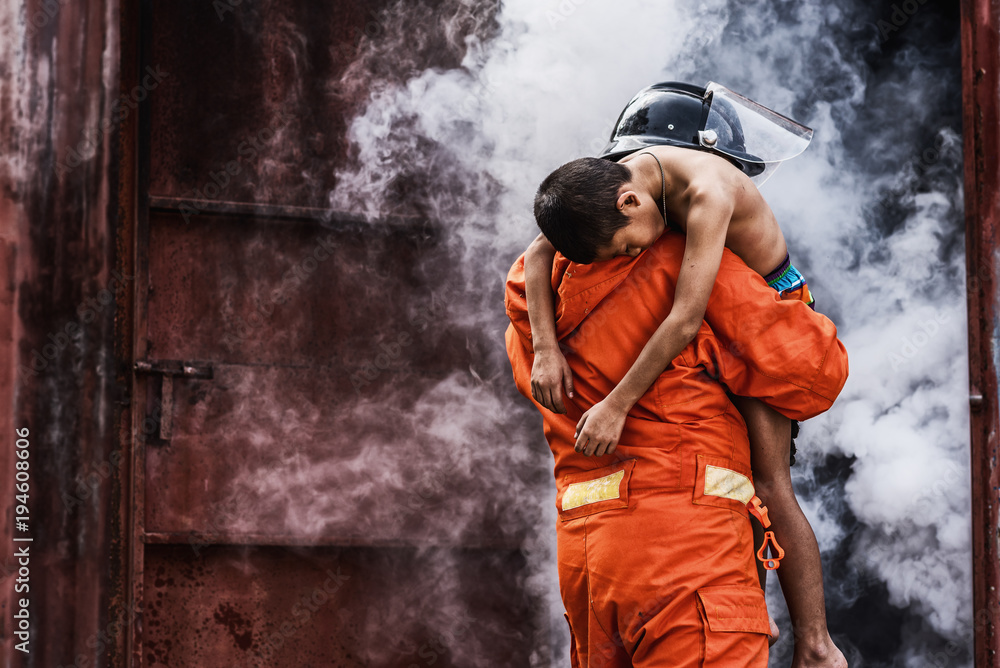 Firefighter holding child boy to save him in fire and smoke,Firemen ...