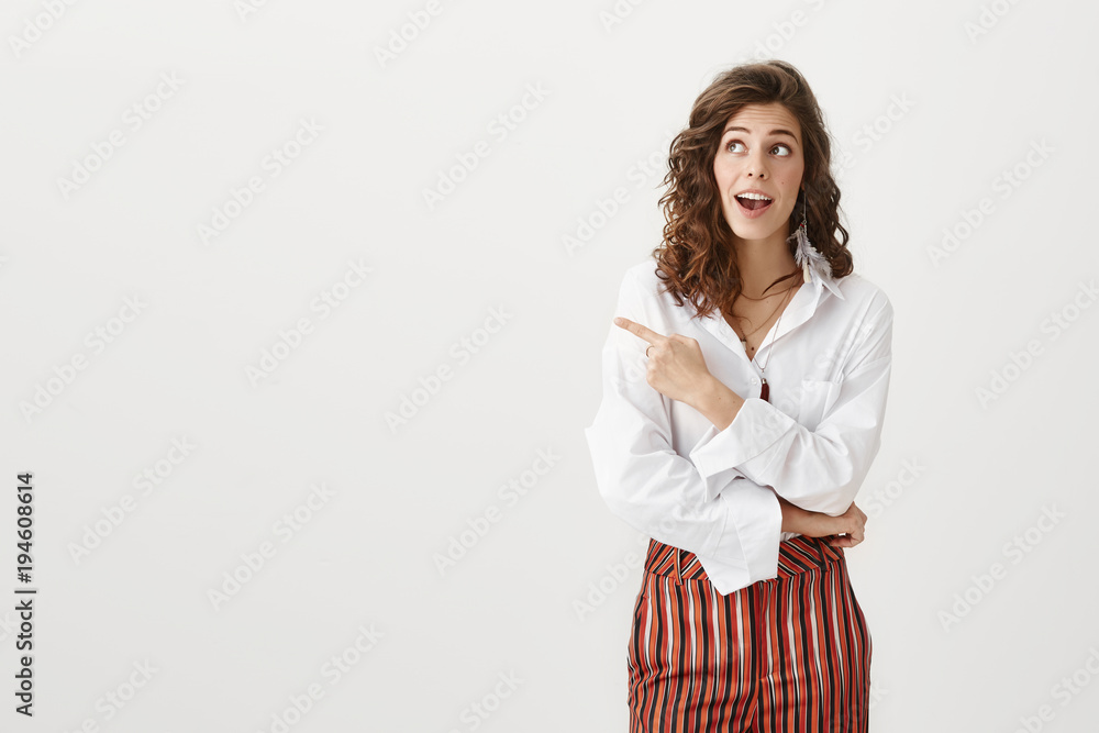 Indoor shot of stylish modern female in middle of conversation pointing ...