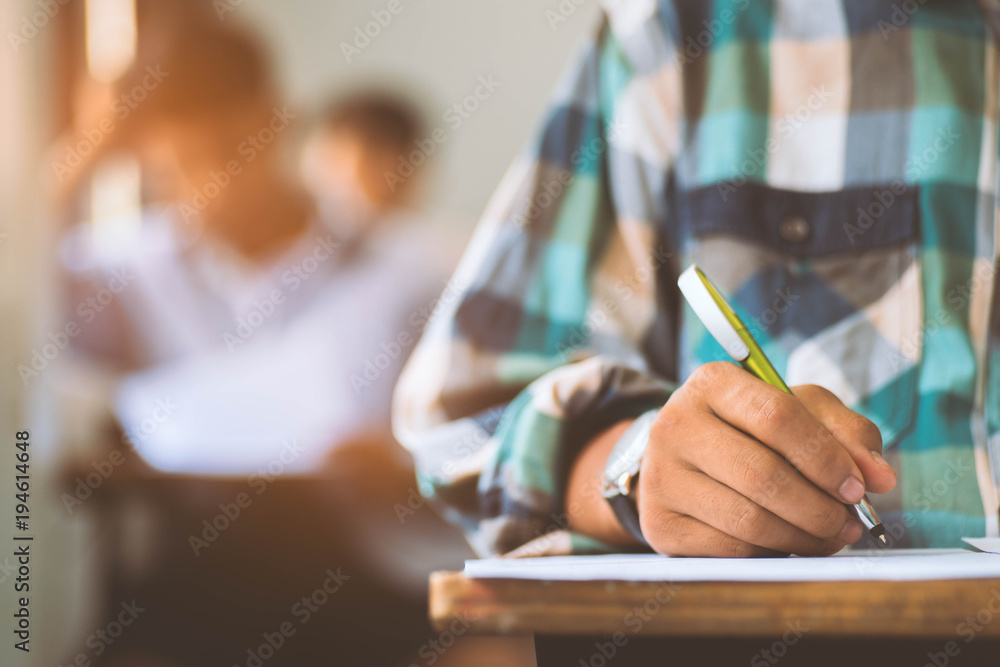 Students writing and reading exam answer sheets exercises in classroom ...