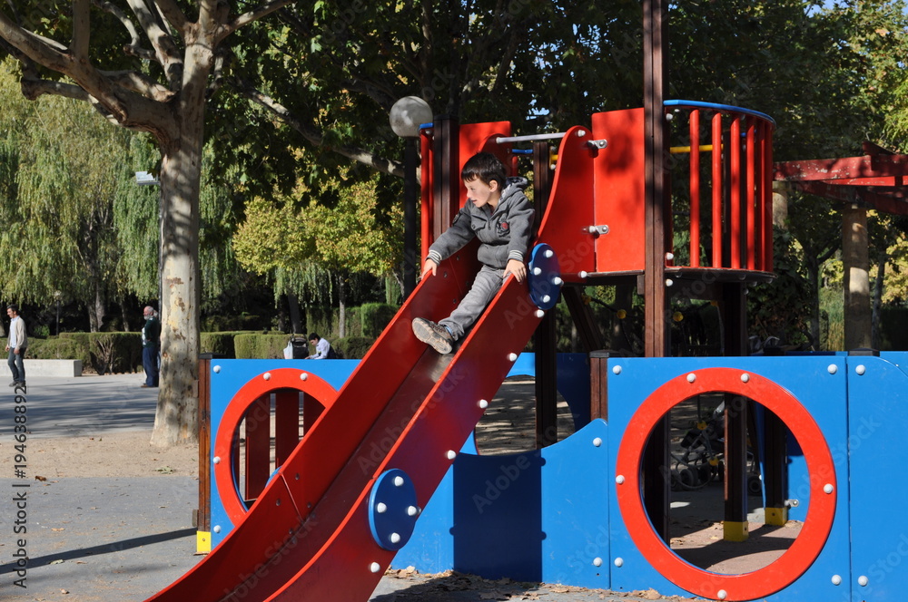 Niño jugando en un parque infantil Stock Photo | Adobe Stock