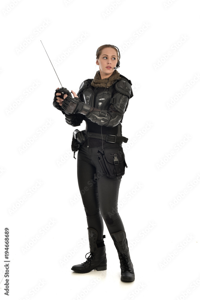 full length portrait of female soldier wearing black tactical armour ...