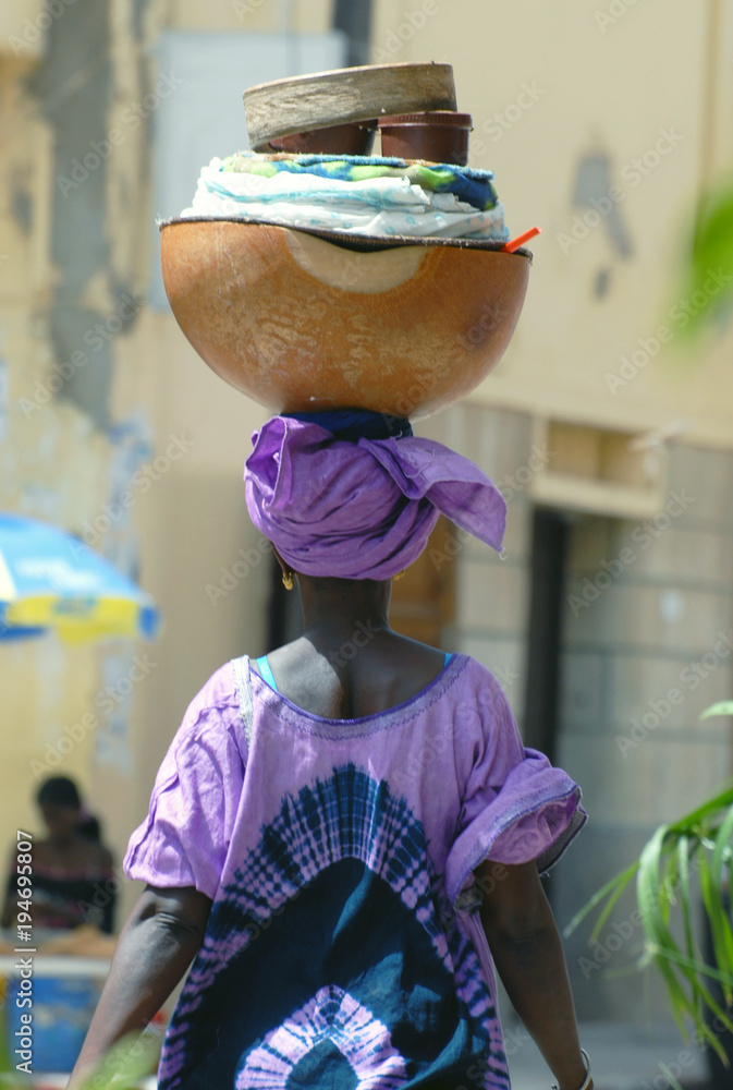 Femme africaine en boubou mauve et de dos, bassine sur la tête, Afrique ...