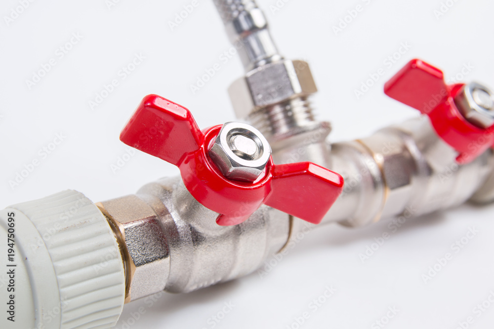 Plumbing gate ball vales, flexible water hose and fittings on a white ...