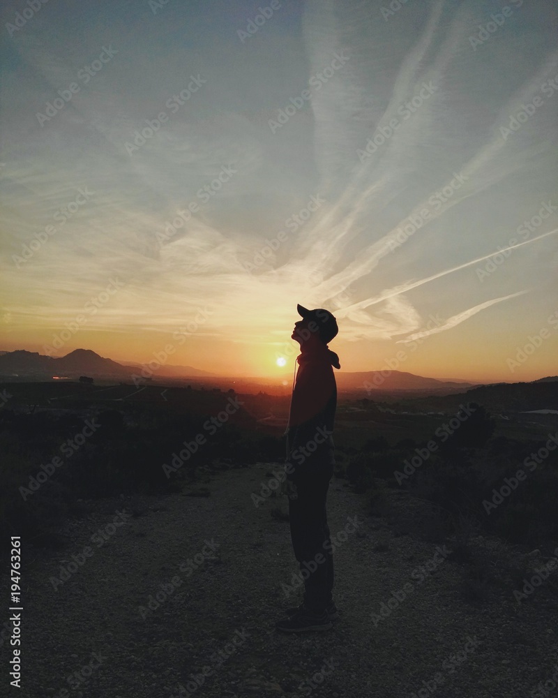 Young male in front of the sunset. Stock Photo | Adobe Stock