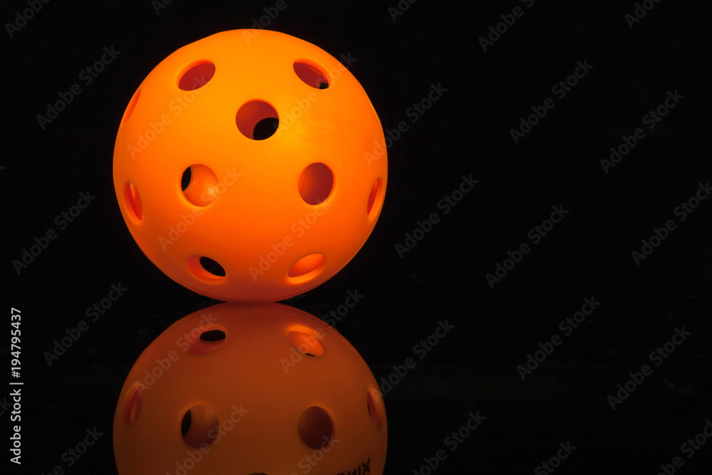 Mirrored Orange Pickleball...Orange Pickleball on a Black background ...