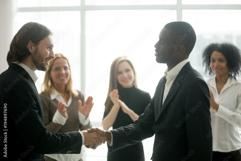 Smiling boss awarding congratulating african american employee with ...
