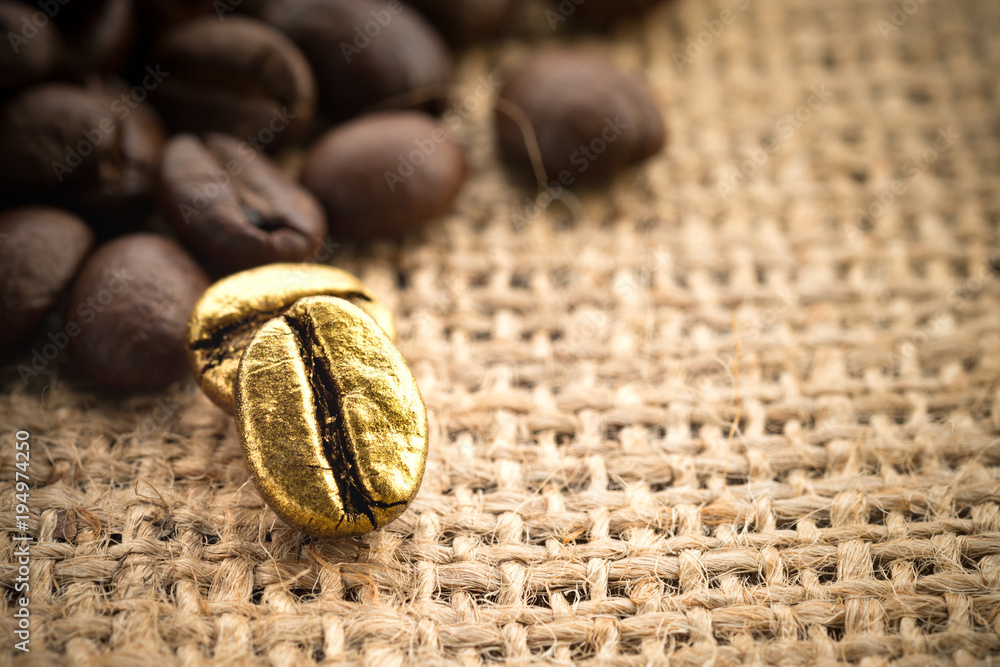 Gold coffee beans on a pile of coffee beans. The concept of luxury is ...