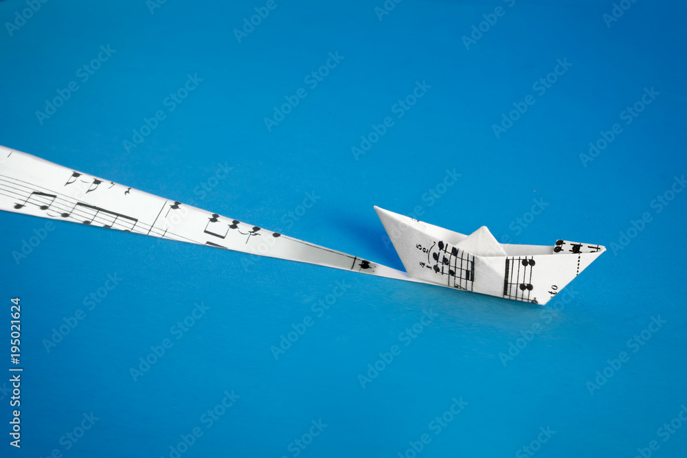 Paper boat made of musical score sheet in blue background Stock Photo ...