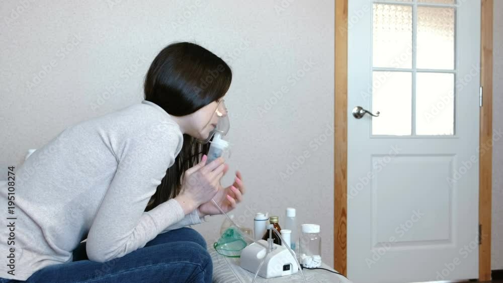 Use nebulizer and inhaler for the treatment. Young woman inhaling ...