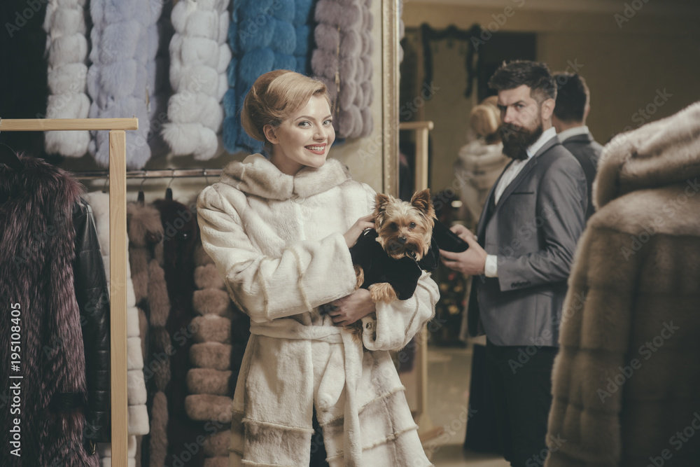 Woman in fur coat with dog and man in shop. Stock Photo | Adobe Stock