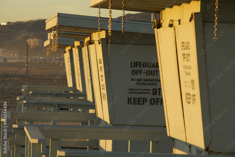 Closed lifeguards stands lined up next to each other on the beach in ...