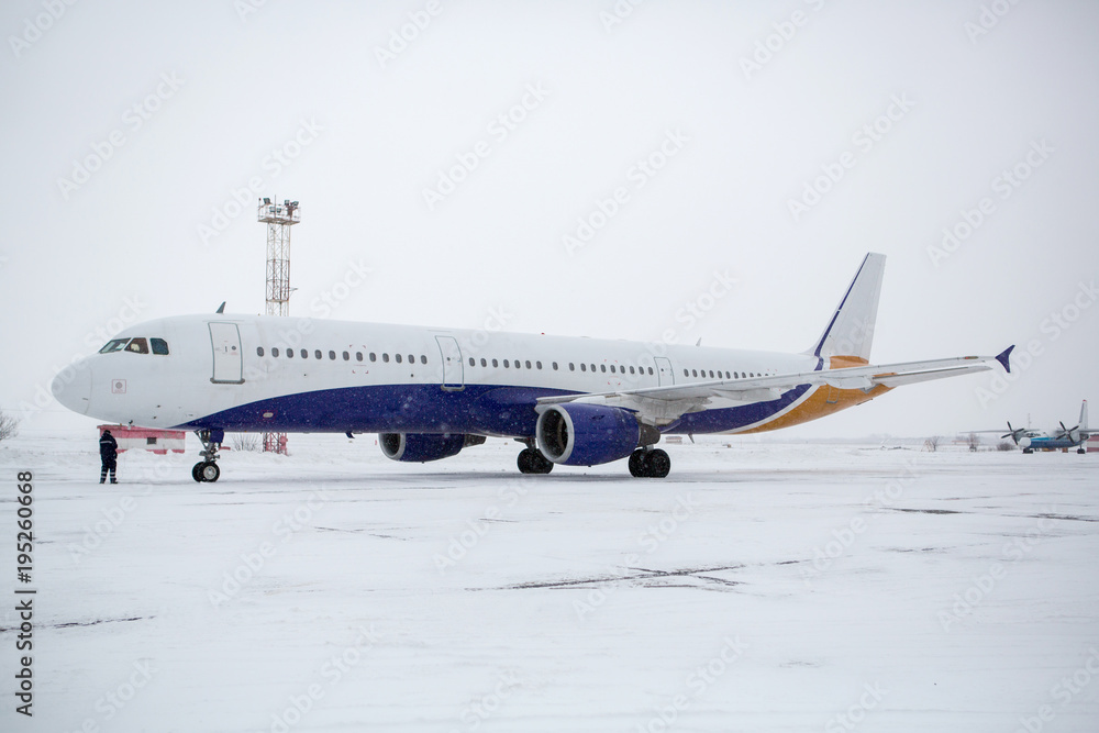 Airliner on runway in blizzard. Aircraft during taxiing at heavy snow ...