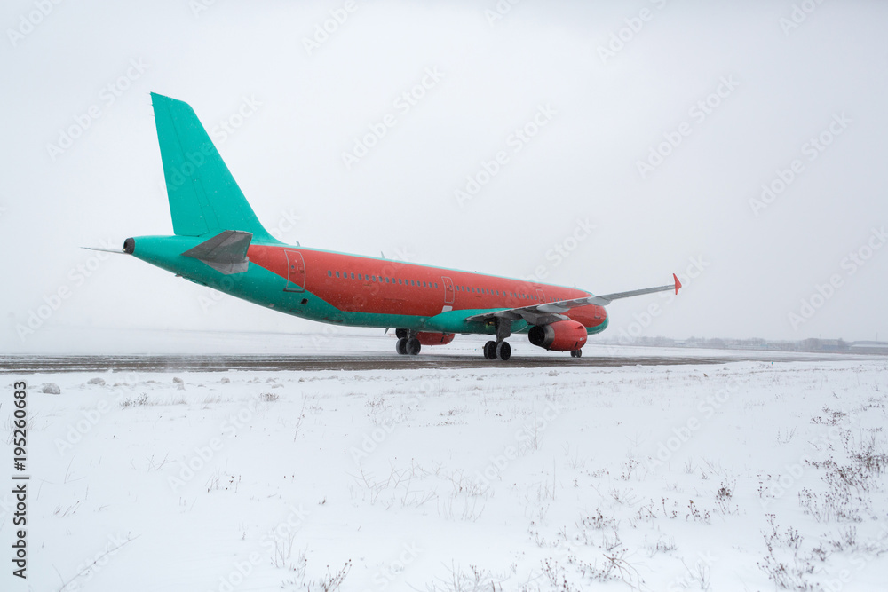 Airliner on runway in blizzard. Aircraft during taxiing at heavy snow ...