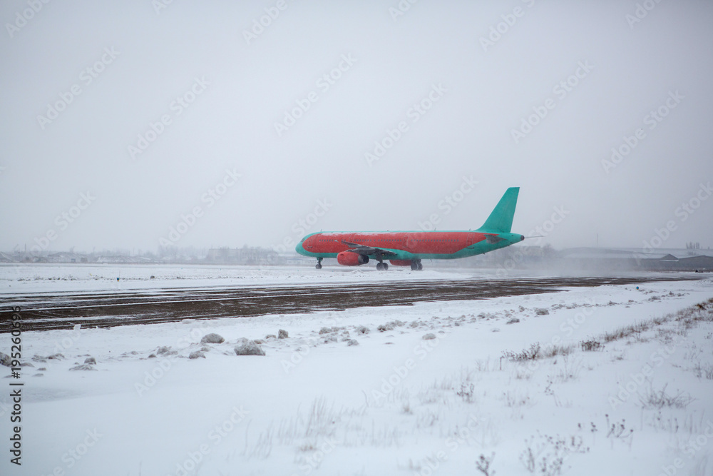 Airliner on runway in blizzard. Aircraft during taxiing at heavy snow ...