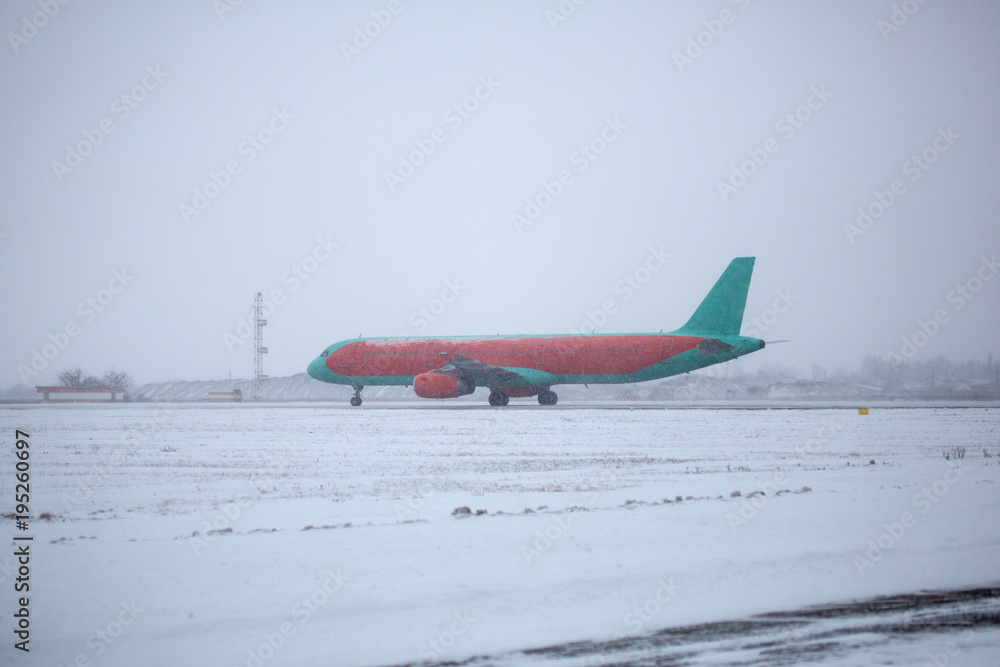 Airliner on runway in blizzard. Aircraft during taxiing at heavy snow ...
