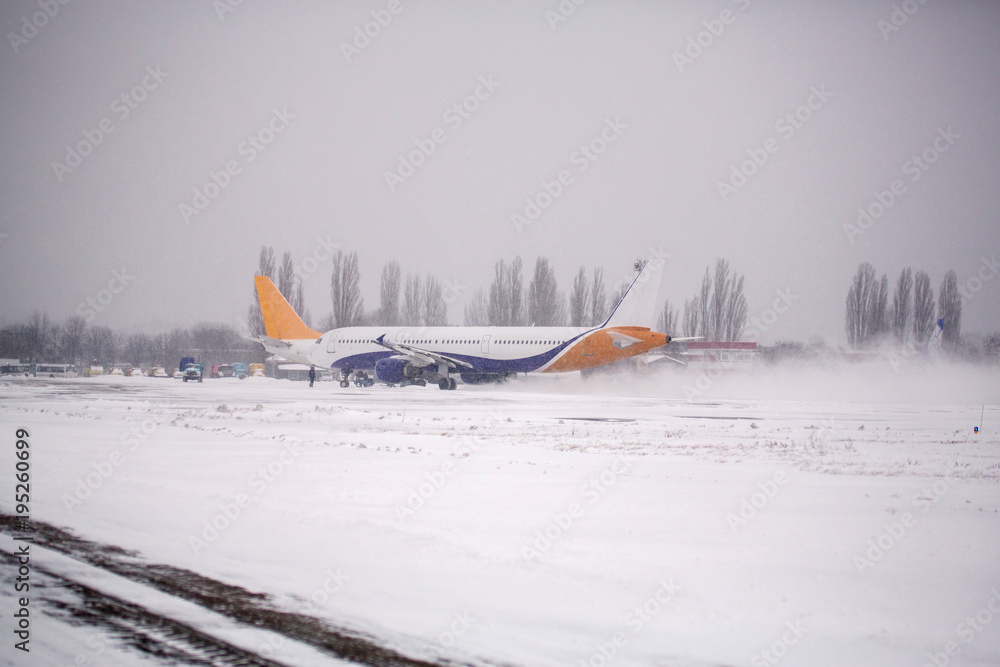 Airliner on runway in blizzard. Aircraft during taxiing at heavy snow ...