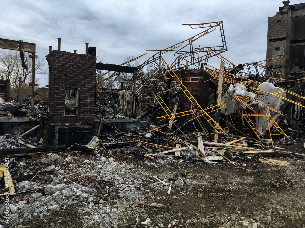 Twisted scaffolding and debris in the burnt aftermath of a building ...