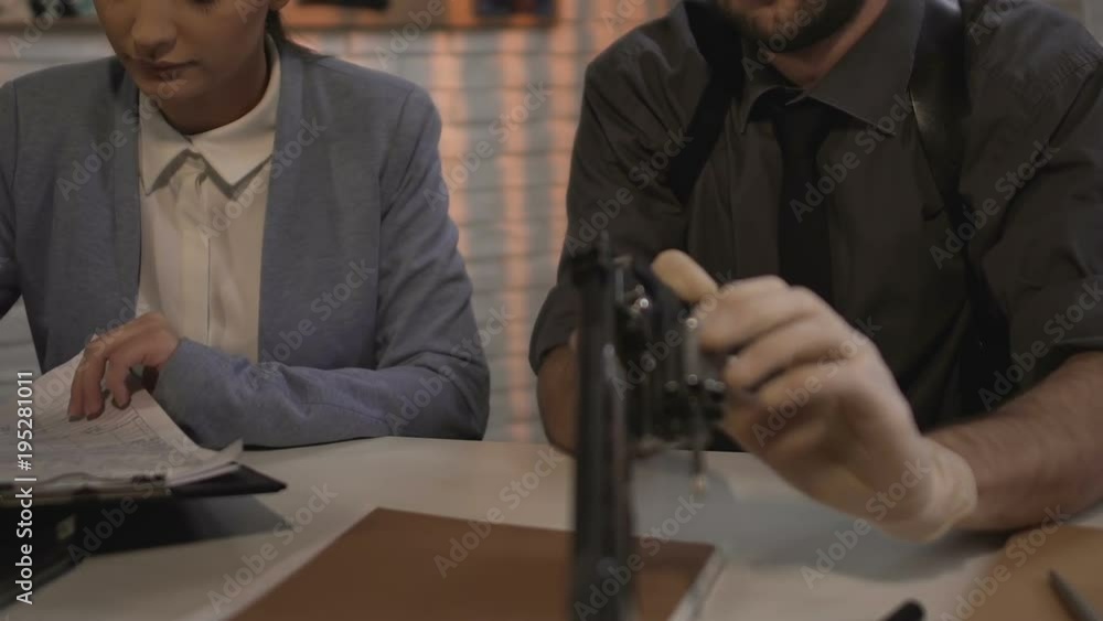 Male ballistics expert checking capacity of gun from crime scene ...