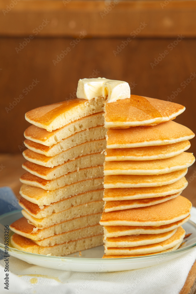 Vertical image of cut stack of pancake with honey and butter on top ...