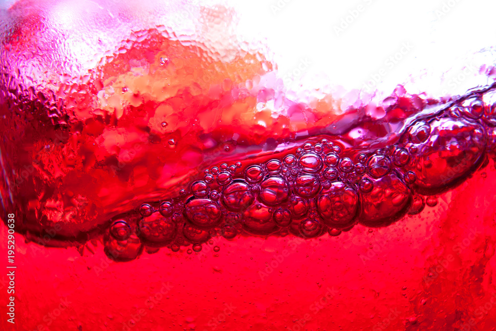 red soda water splashing with bubbles close up and Dew Point on glass ...
