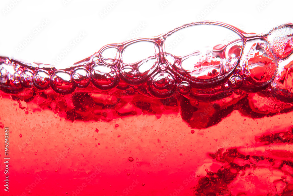red soda water splashing with bubbles close up and Dew Point on glass ...