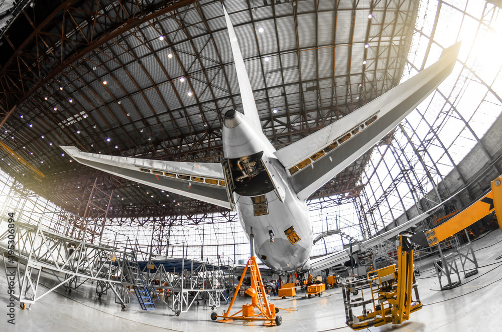 Large passenger aircraft on service in an aviation hangar rear view of ...