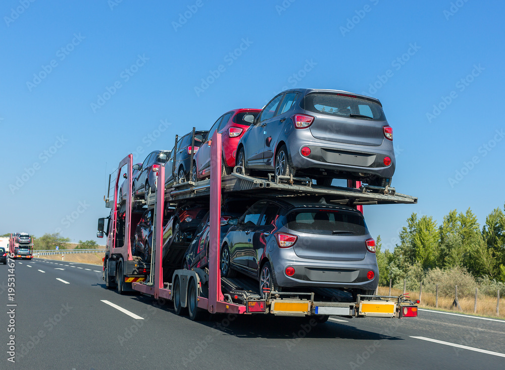 Car carrier trailer with cars on bunk platform. Car transport truck on ...