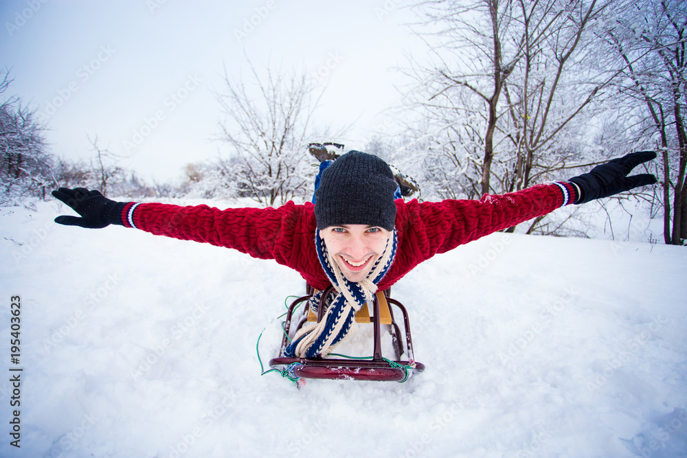 Crazy man enjoy a sleigh ride. Man sledding. Funny man play outdoors in ...