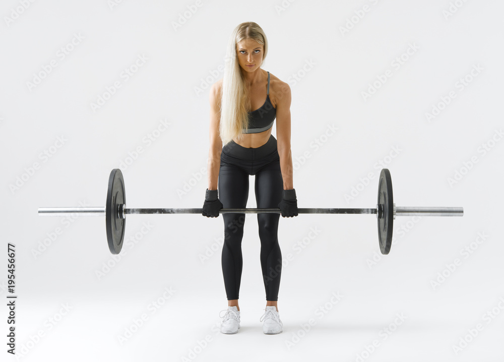 Front view of confident young blonde woman doing weight lifting workout ...
