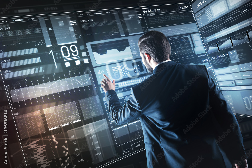 New data. Calm confident young programmer touching a transparent screen ...