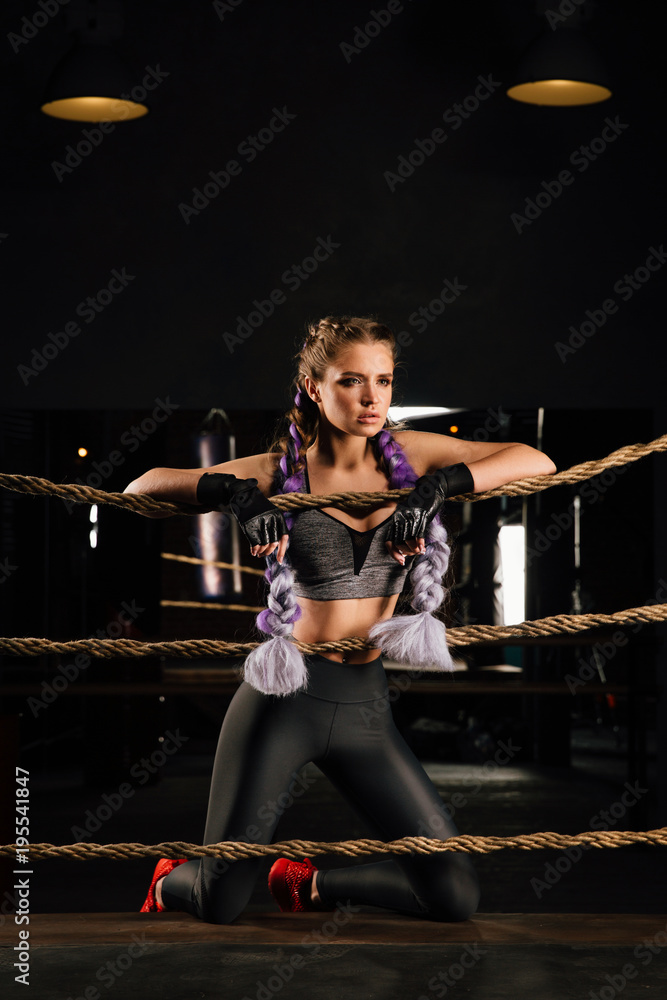 Sexy boxing girl leaned kneels on ropes of competition ring ...