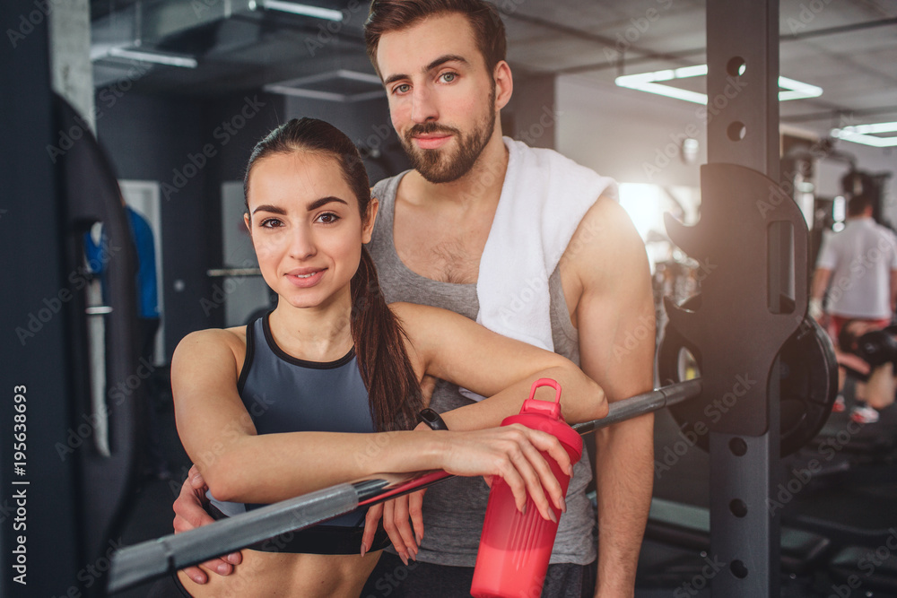 Fantastic couple is standing together in the training room and posing ...