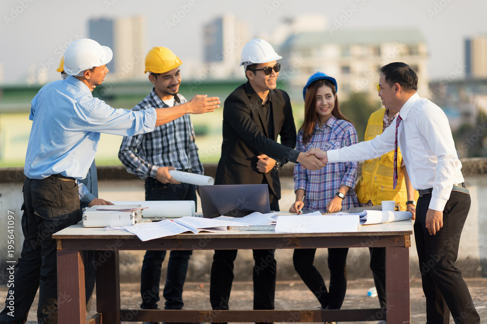 Business man handshake with engineer with teamwork over rooftop. Success in engineering project ...