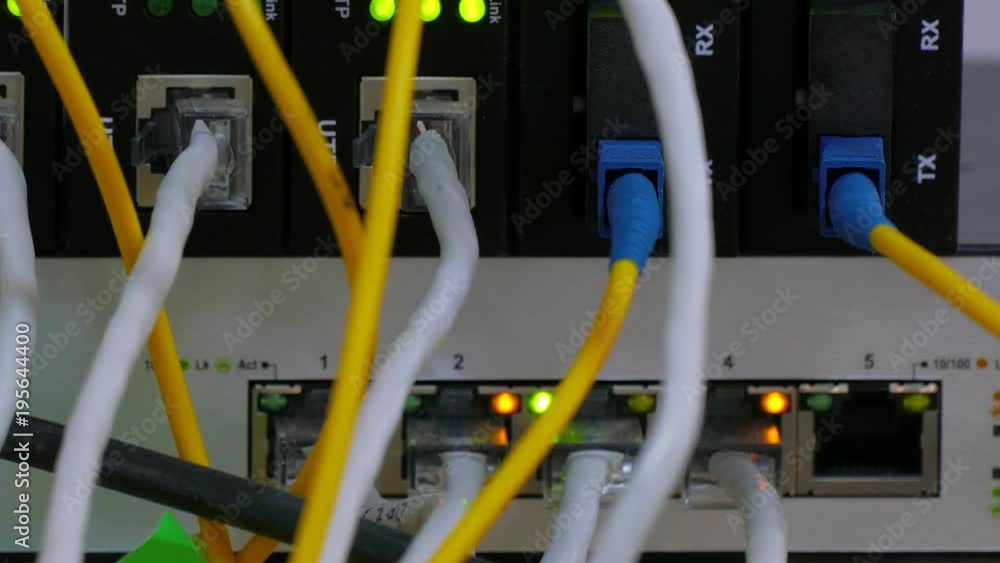 Media Converters. Fiber Optic cables connected to an optic ports and ...