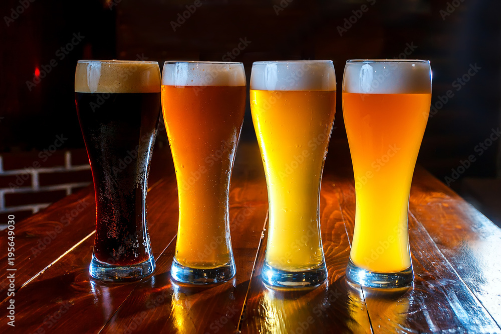 four types of beer: dark, light, red, white. In a dark pub Stock Photo ...