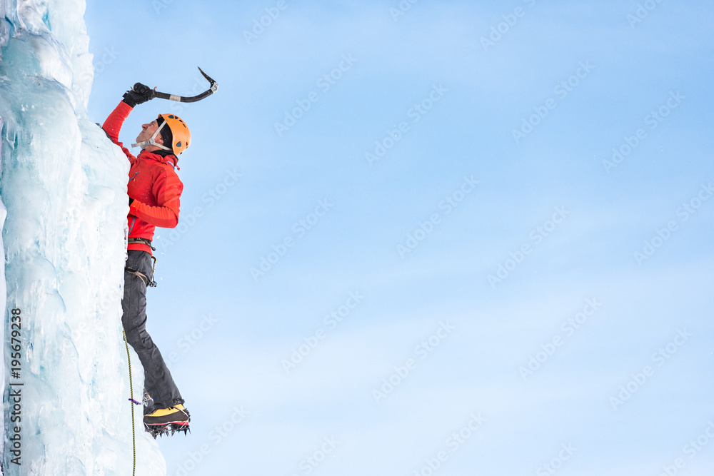 Male ice climber hitting the frozen waterfall with ice axe Stock Photo ...