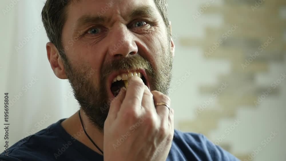 bearded man eating junk food with great enjoyment. guy eats french ...