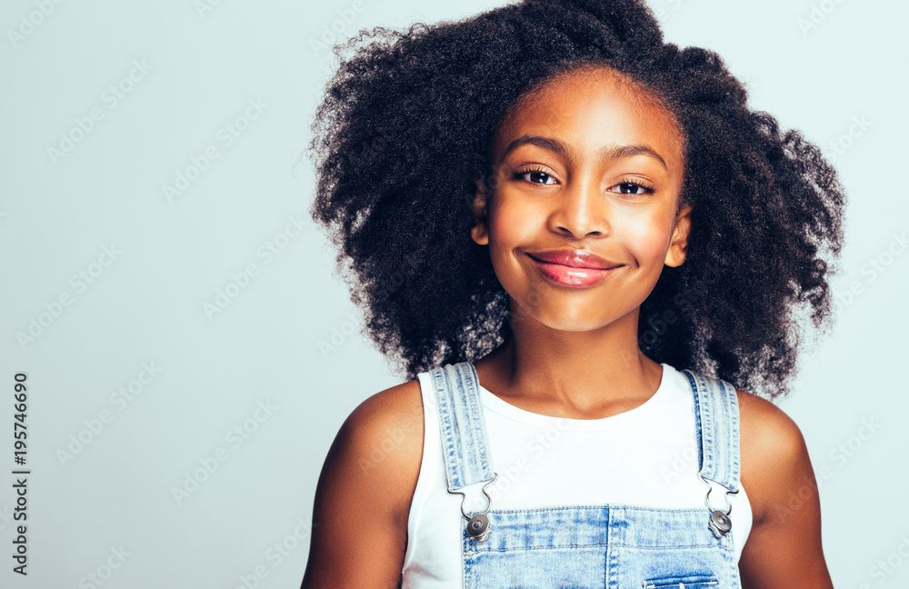 Adorable little African girl smiling against a gray background Stock ...