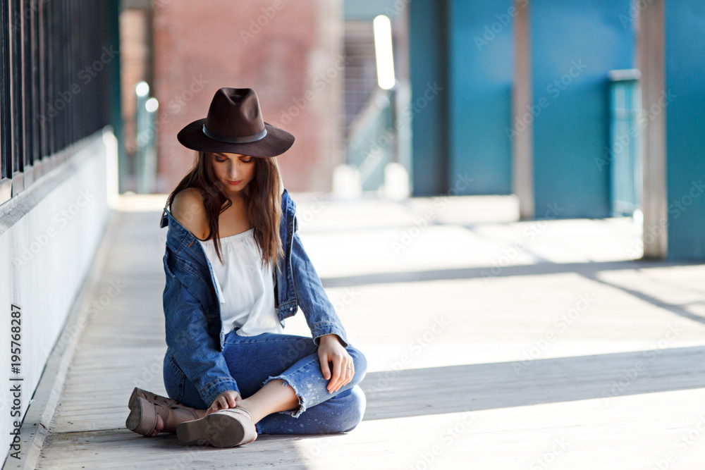 young woman sprained her legs. sad girl sitting on the ground and ...