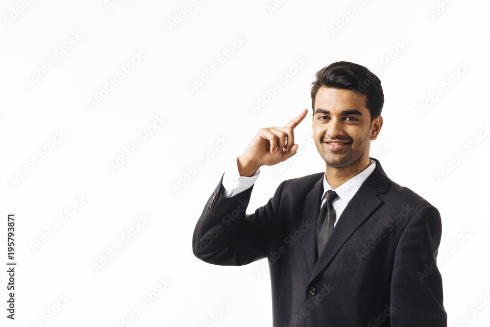 Businessman in suit and tie pointing at his head, isolated on white ...