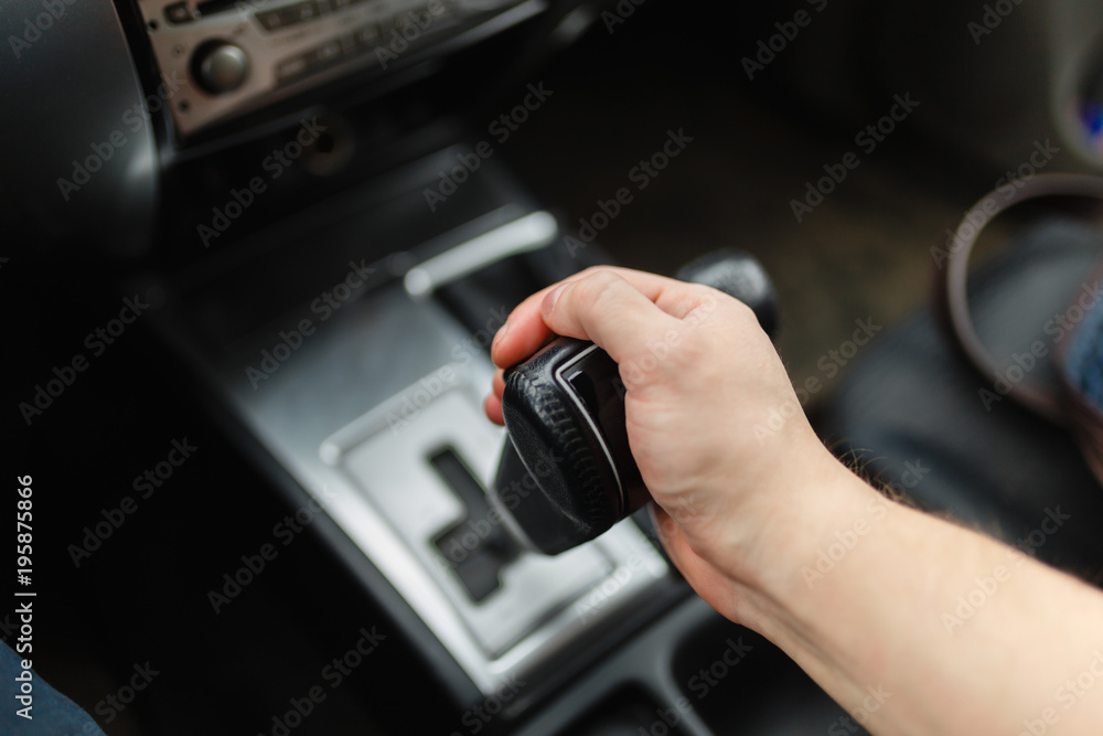 Male hand switches automatic transmission closeup. Close up view of ...