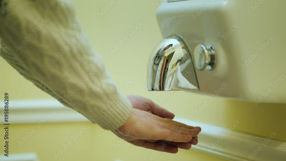 The man dries his hands under a stream of hot air. Hand dryer Stock ビデオ ...