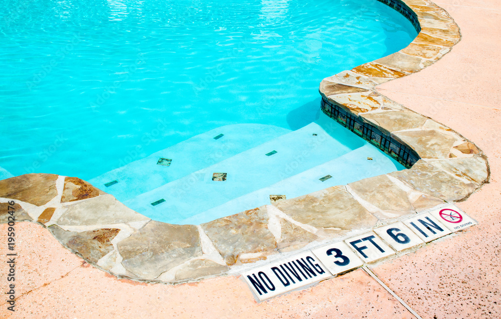 No Diving warning sign near swimming pool steps with limestone border ...