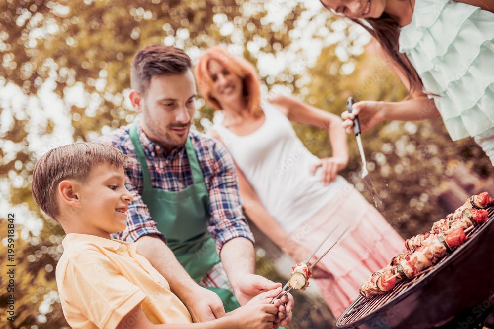 Family having a barbecue party,standing around the grill Stock Photo ...