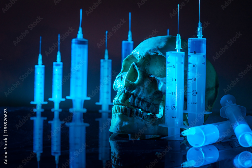 Syringes on a black table. A human skull. Addiction. syringes with ...