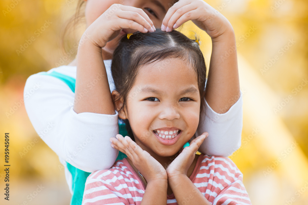 Happy asian little child girl making hand in heart shape with her ...