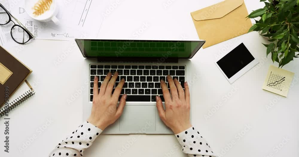Top view on the office table with laptop computer with green screen and ...