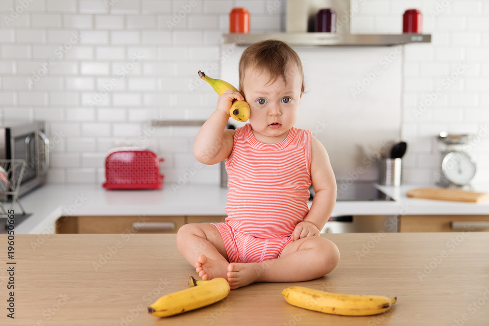 Baby pretending to make a phone call with banana against his ear Stock ...