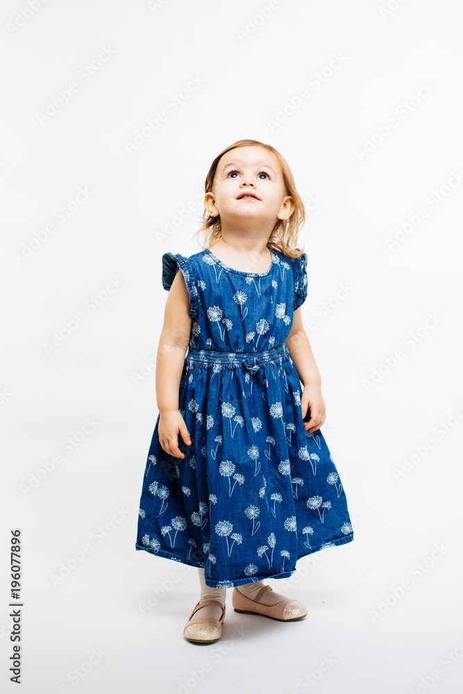 Full body portrait of a cute little preschool girl looking up on white ...